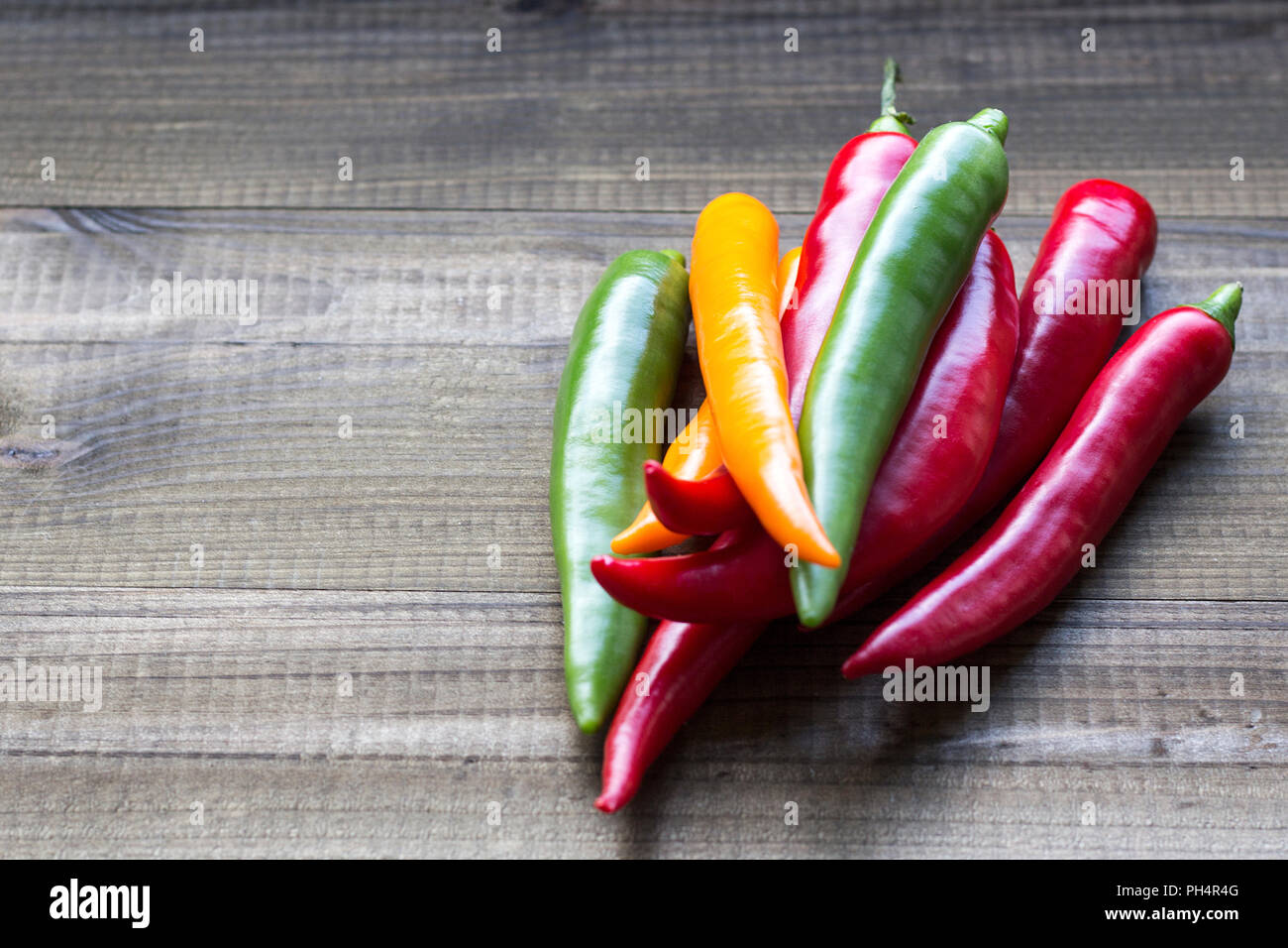 chilli peppers on wooden background Stock Photo - Alamy