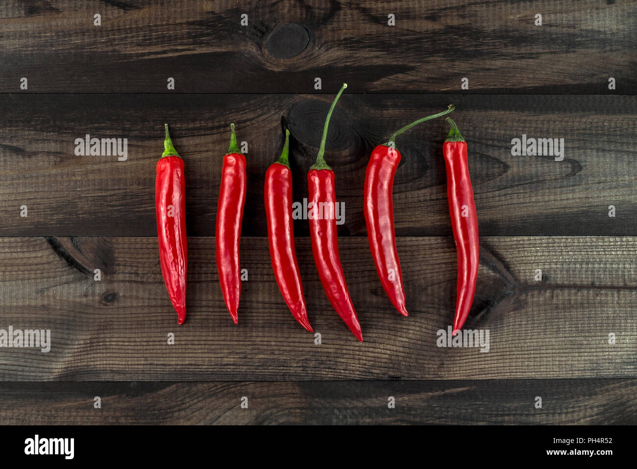 chilli peppers on wooden background Stock Photo - Alamy