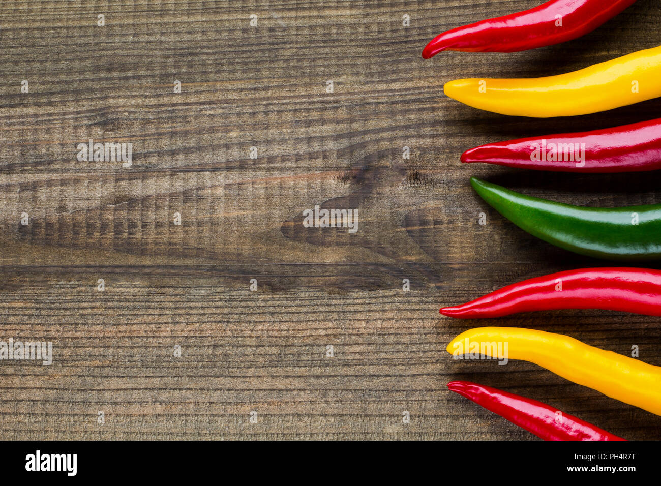 chilli peppers on wooden background Stock Photo - Alamy
