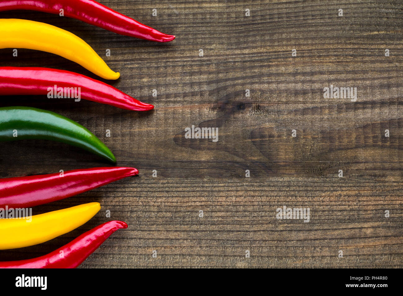 chilli peppers on wooden background Stock Photo - Alamy