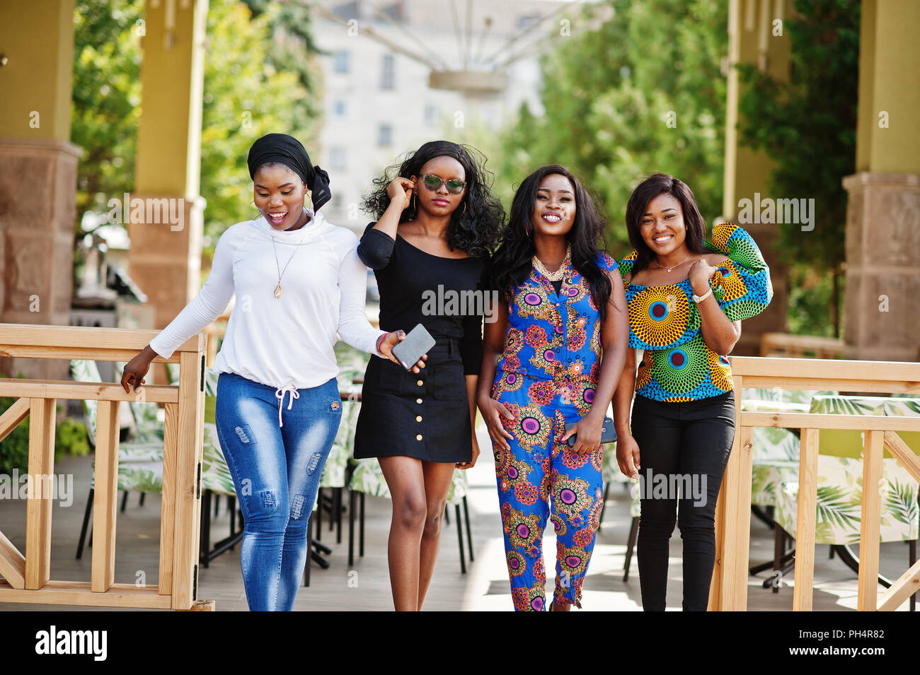 Group of four african american girls posed outdoor against city ...