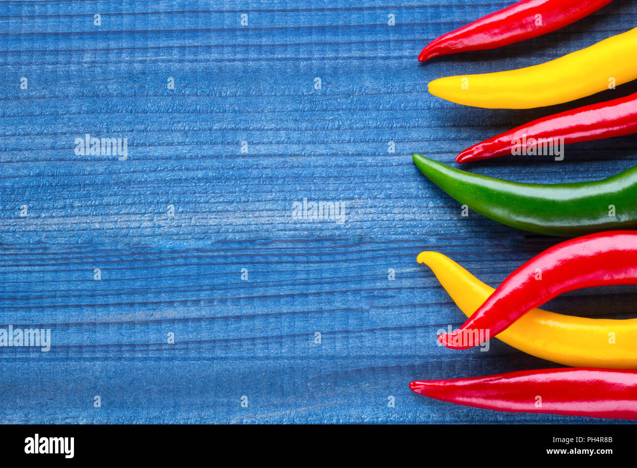 chilli peppers on wooden background Stock Photo - Alamy