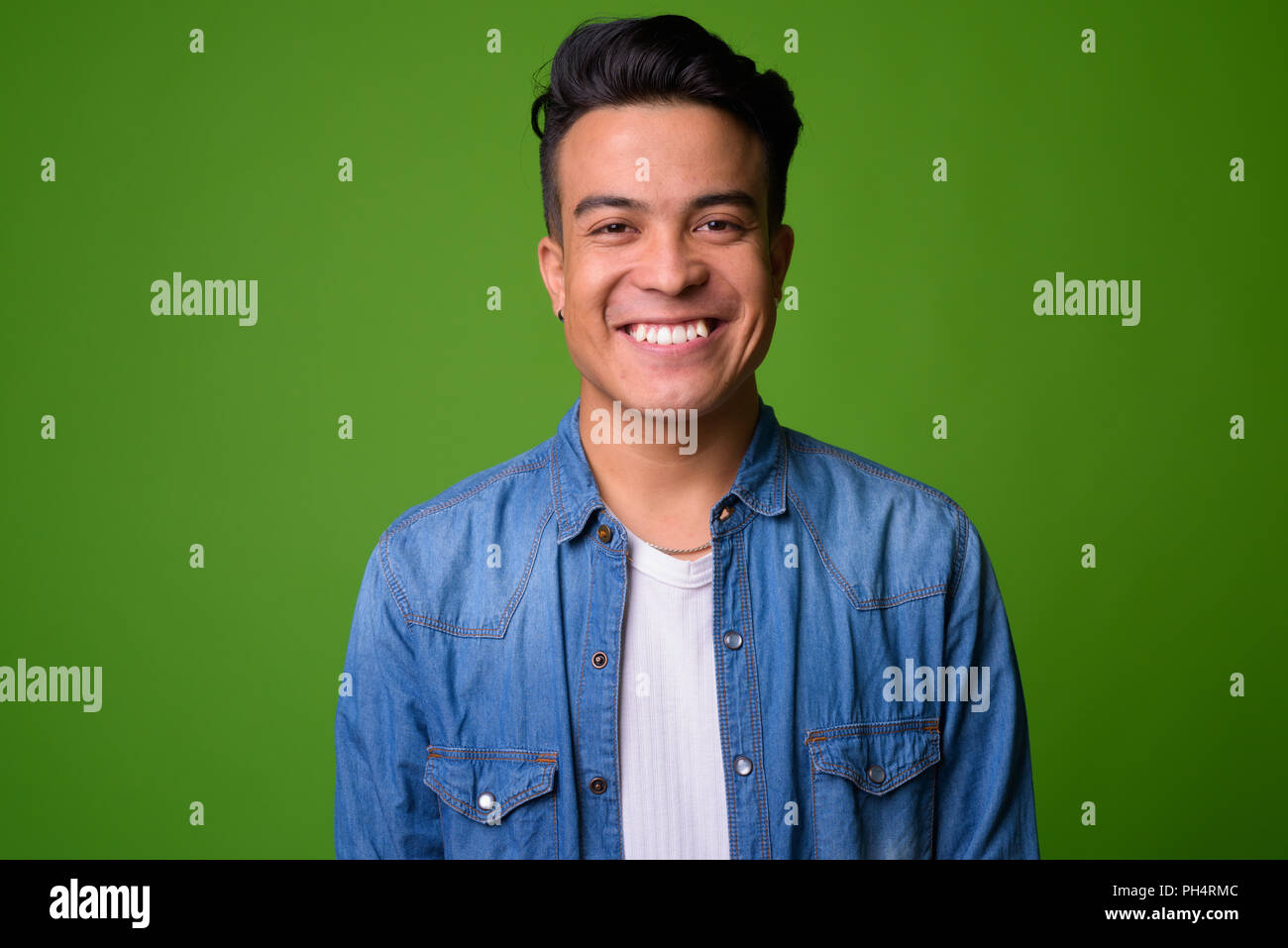 Young multi-ethnic man wearing smart clothing against green background ...