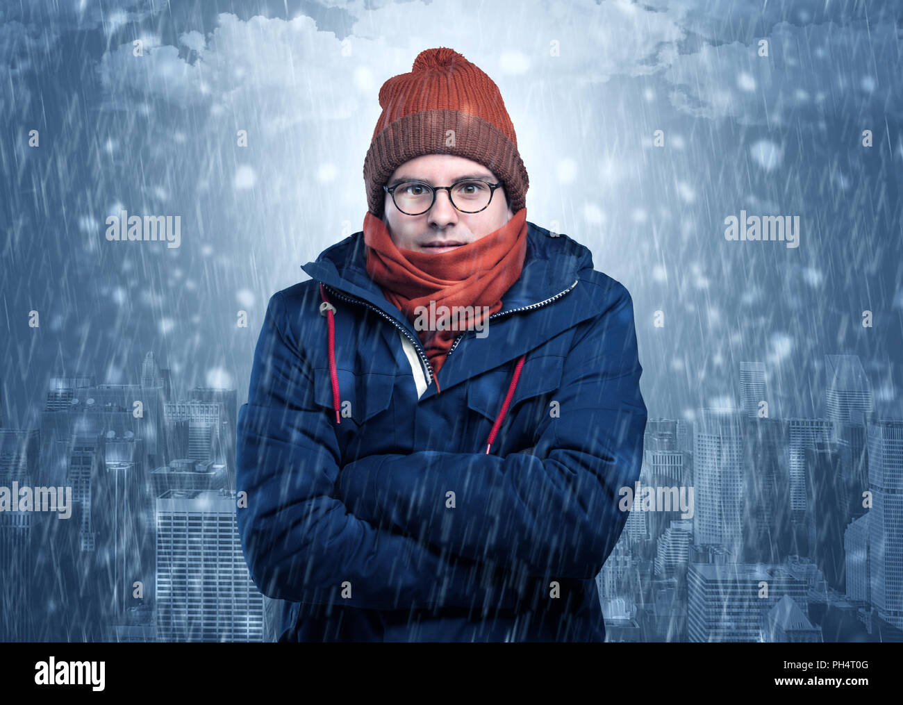 Young man freezing in warm clothing with city concept Stock Photo - Alamy
