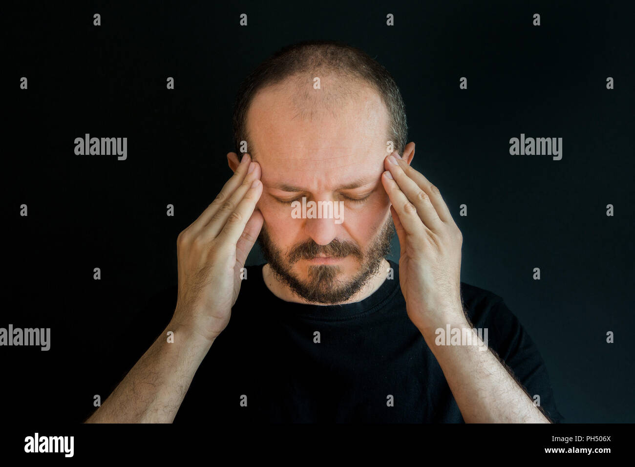 Serious man with beard and mustaches on black background in low key ...