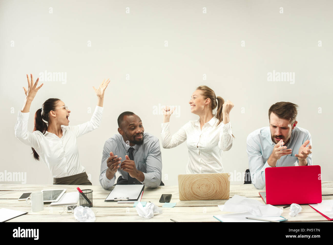 Winners. Young african and caucasian men and women sitting at office ...