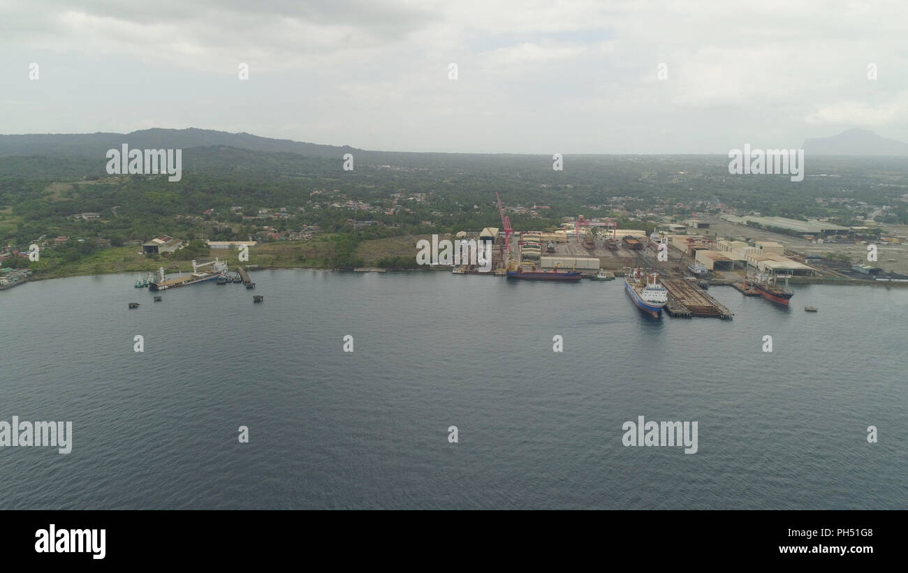 Aerial view of shipyard with ships in docks, cranes and warehouses ...