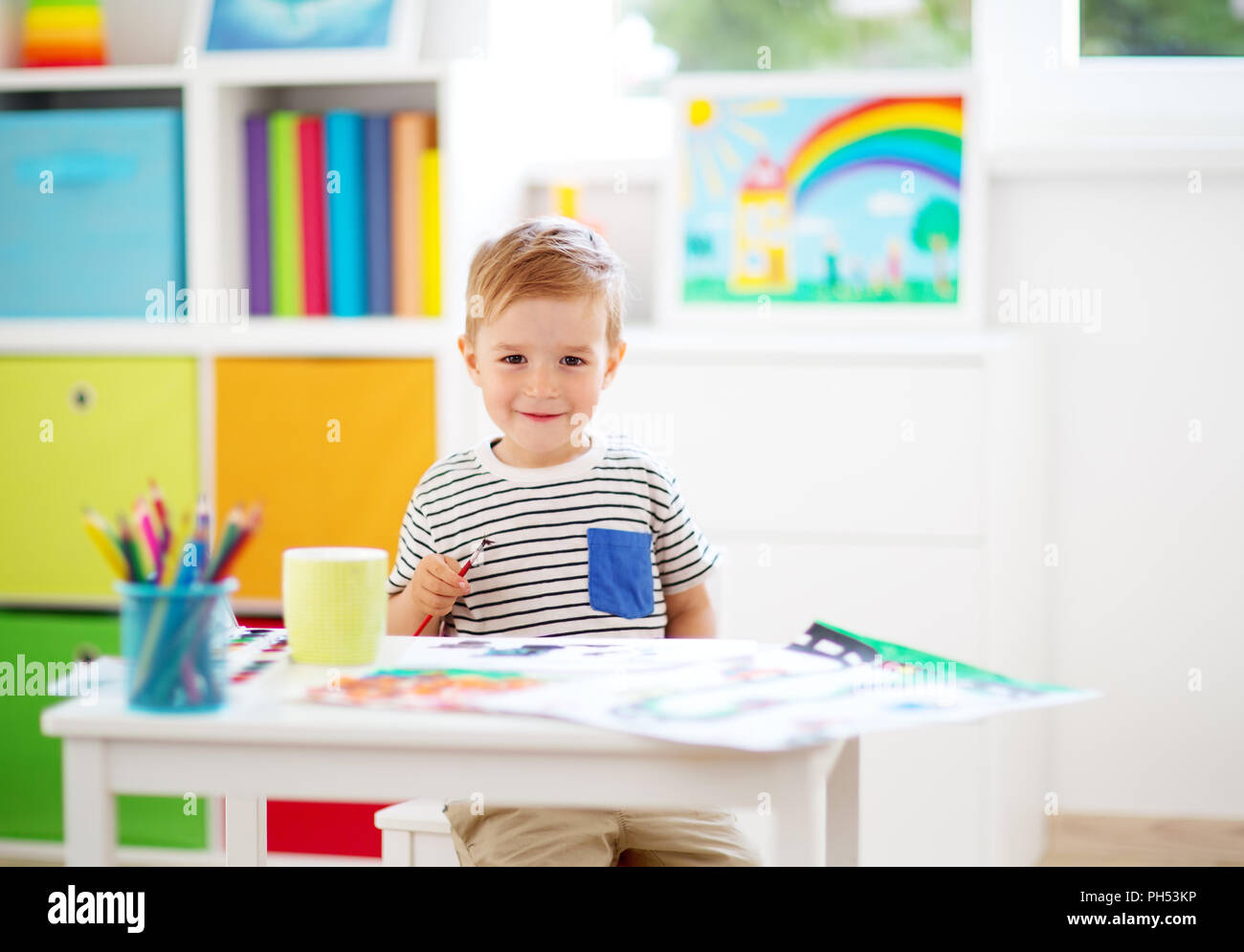 Little child drawing on the paper in room Stock Photo - Alamy
