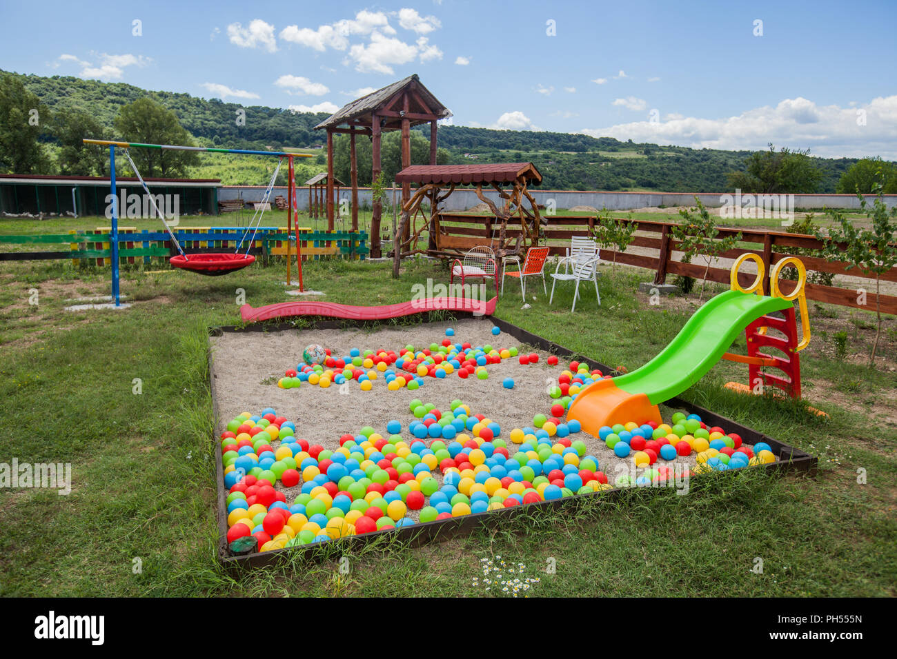 Children playground with slides and colorful balls in the sand outdoor ...