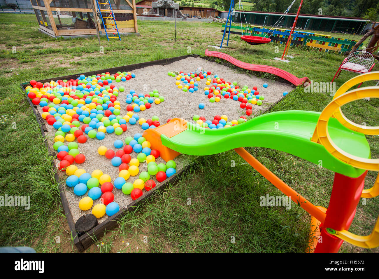 Children playground with slides and colorful balls in the sand outdoor ...