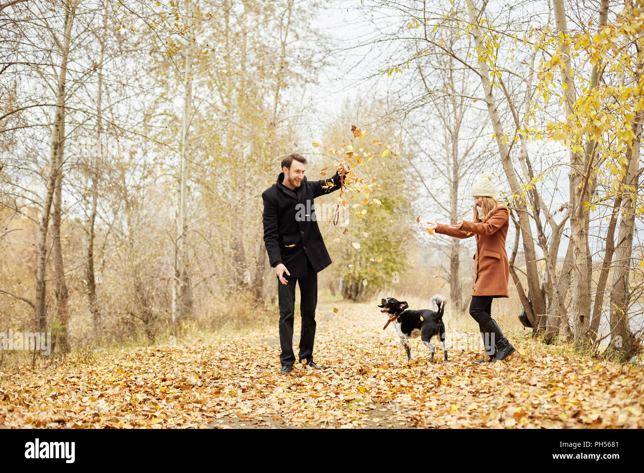 Couple walking with dog in the Park and hugging. Autumn walk men and ...