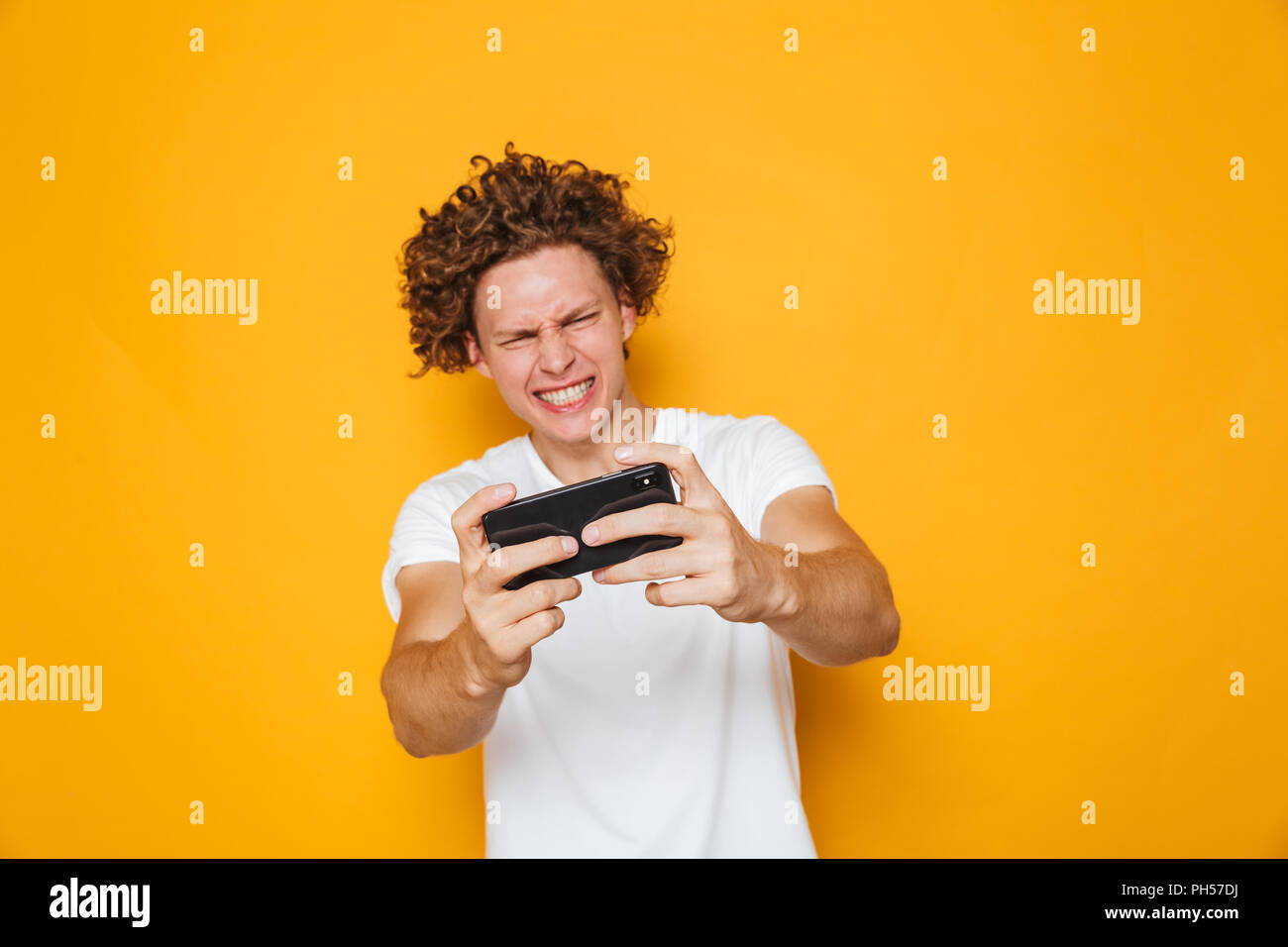 Happy gamer man in casual t-shirt playing online video games on ...