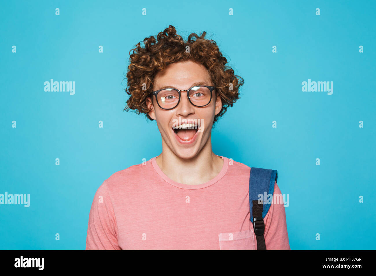 Image of geek guy with curly hair wearing glasses and backpack smiling ...