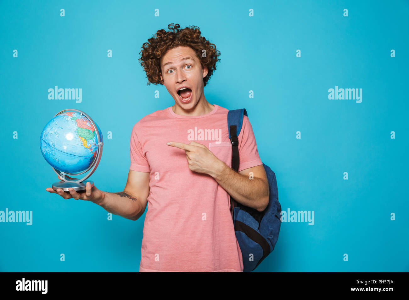 Portrait of geek boy 18-20 with curly hair wearing backpack holding and ...