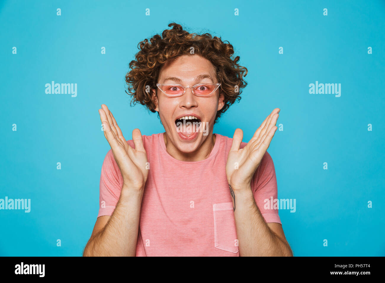 Portrait of a funny curly haired man in sunglasses screaming isolated ...