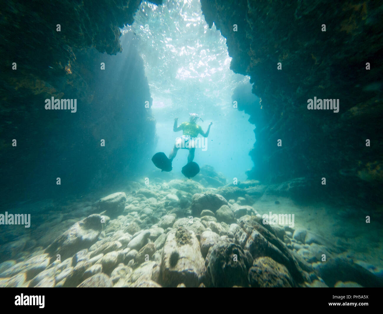 Male diver swimming through natural underwater tunnel Stock Photo - Alamy