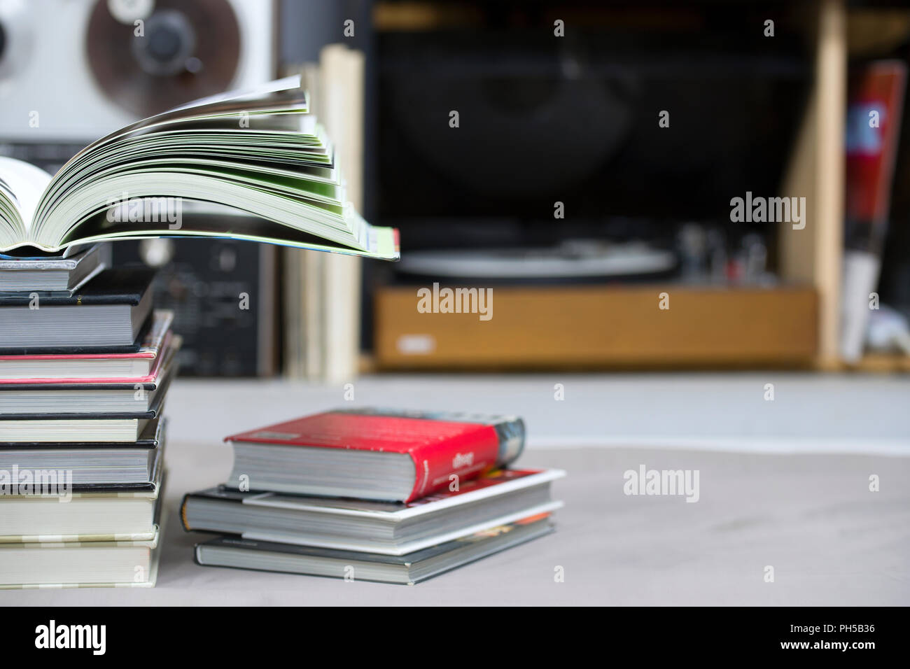 Open book, stack of hardback books on table. Top view Stock Photo - Alamy
