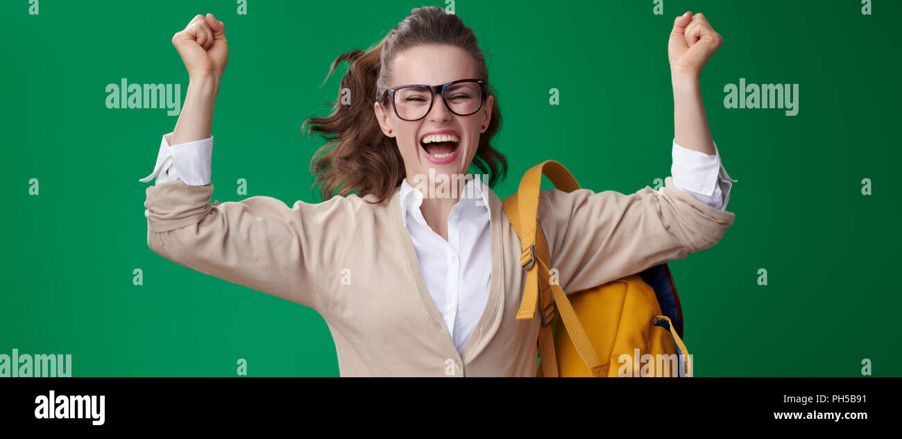 smiling modern student woman jumping and rejoicing isolated on green ...