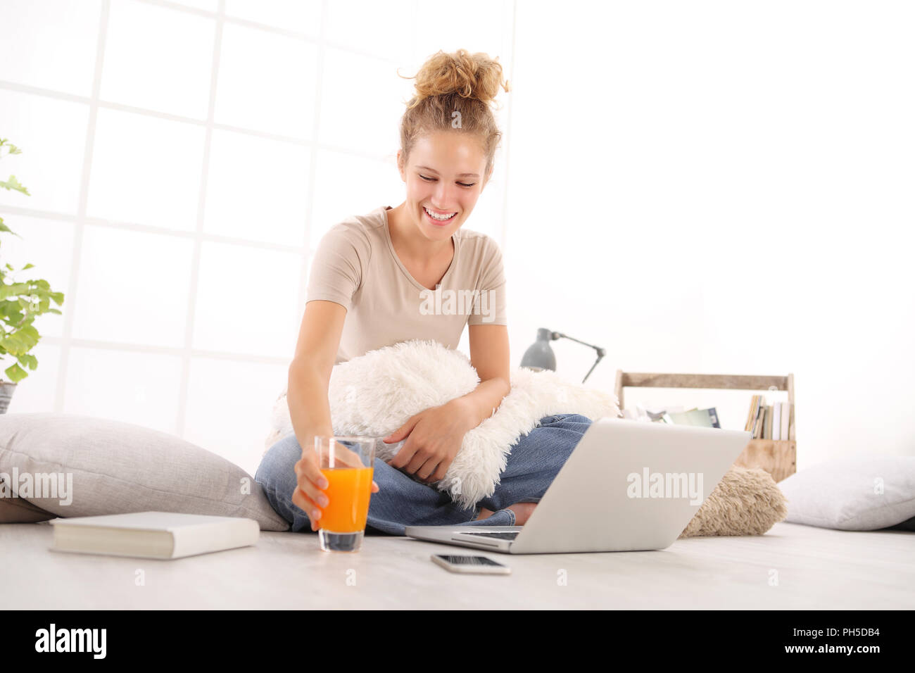 smiling young woman with computer drink orange juice,, sitting on the ...