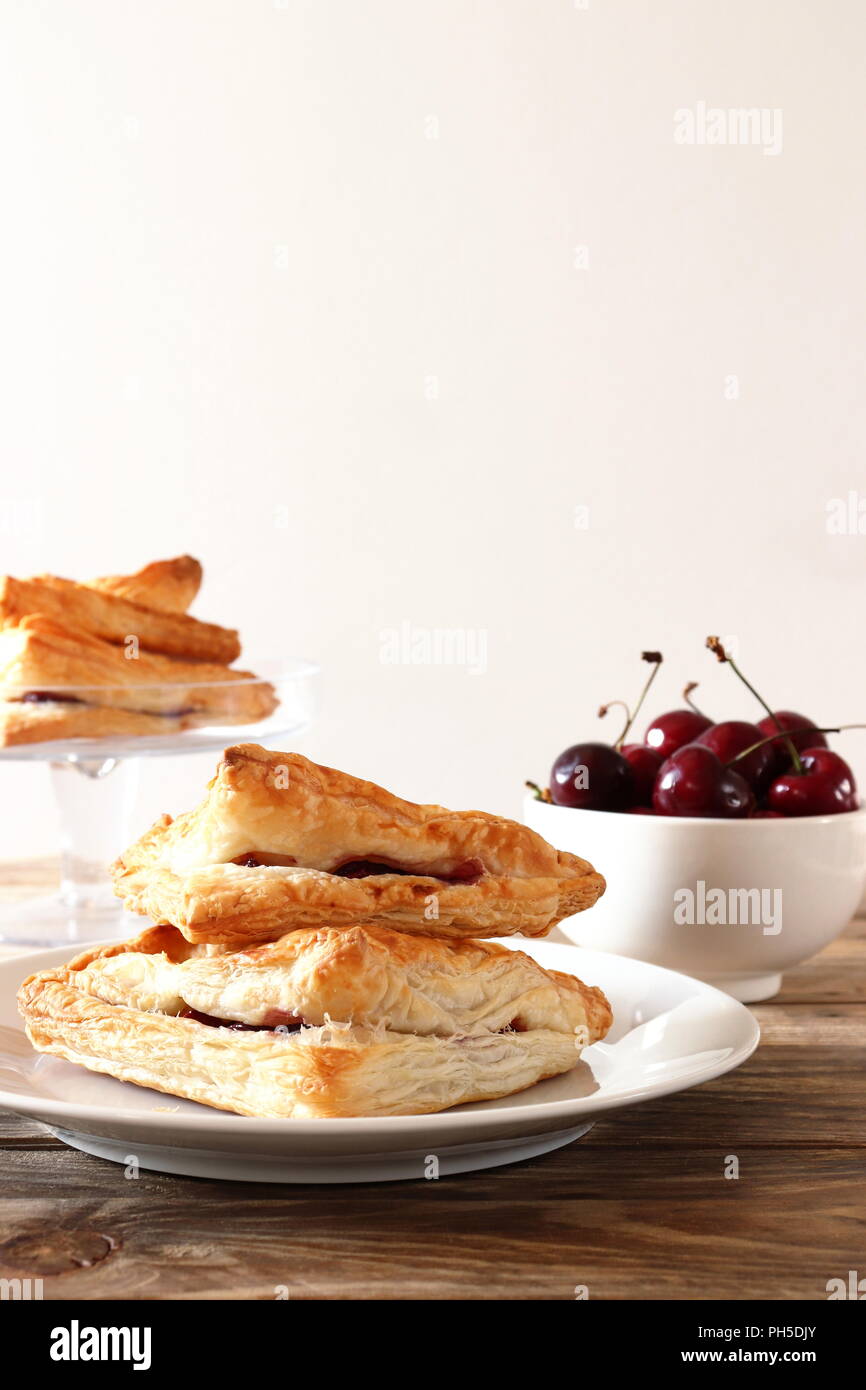 Freshly baked puff pastry triangles with cherries Stock Photo - Alamy