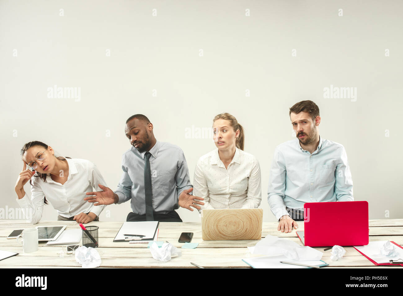 Young upset african and caucasian men and women sitting at office and ...