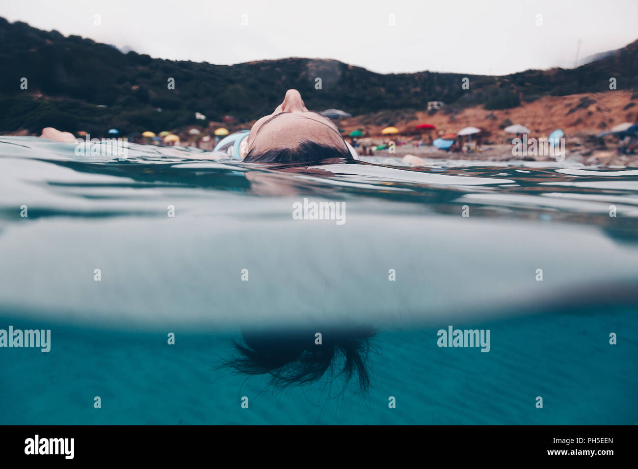 woman taking rest upon the water surface with her eyes closed - relax ...