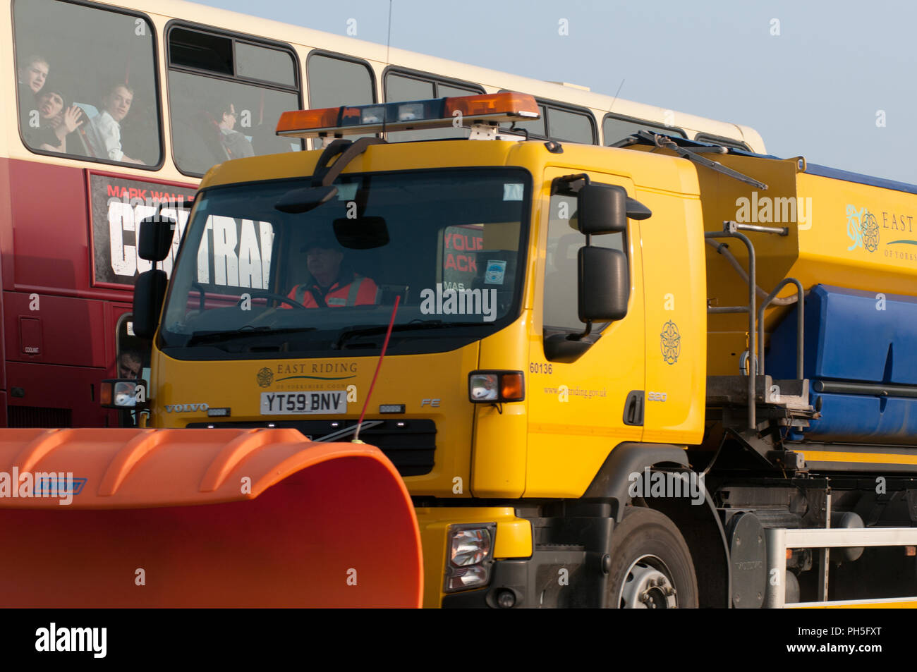 snow plow vehicle driving meets a double decker bus in UK Stock Photo ...