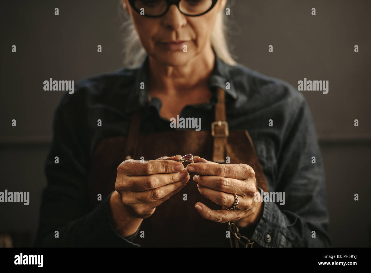 Female jewelry designer examining ring hi-res stock photography and ...