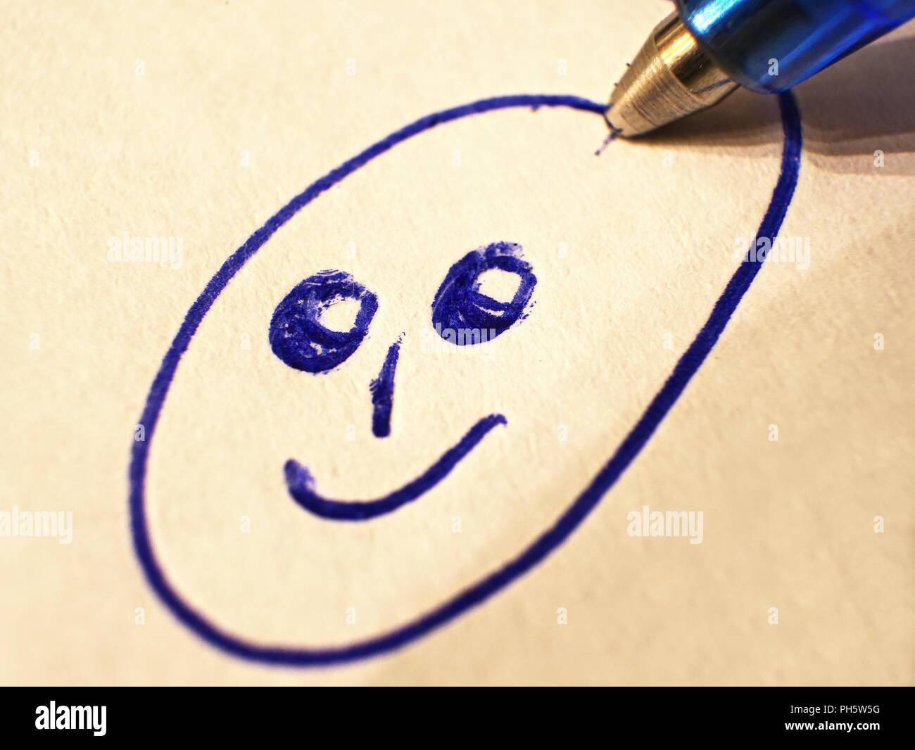 drawing a smiley with blue ballpoint pen, white paper, blue ink ...