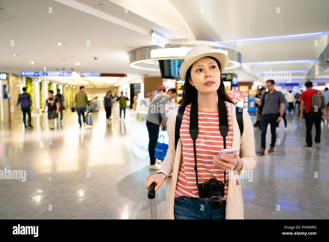 asian visitor searching in service counter holdin the smartphone in ...