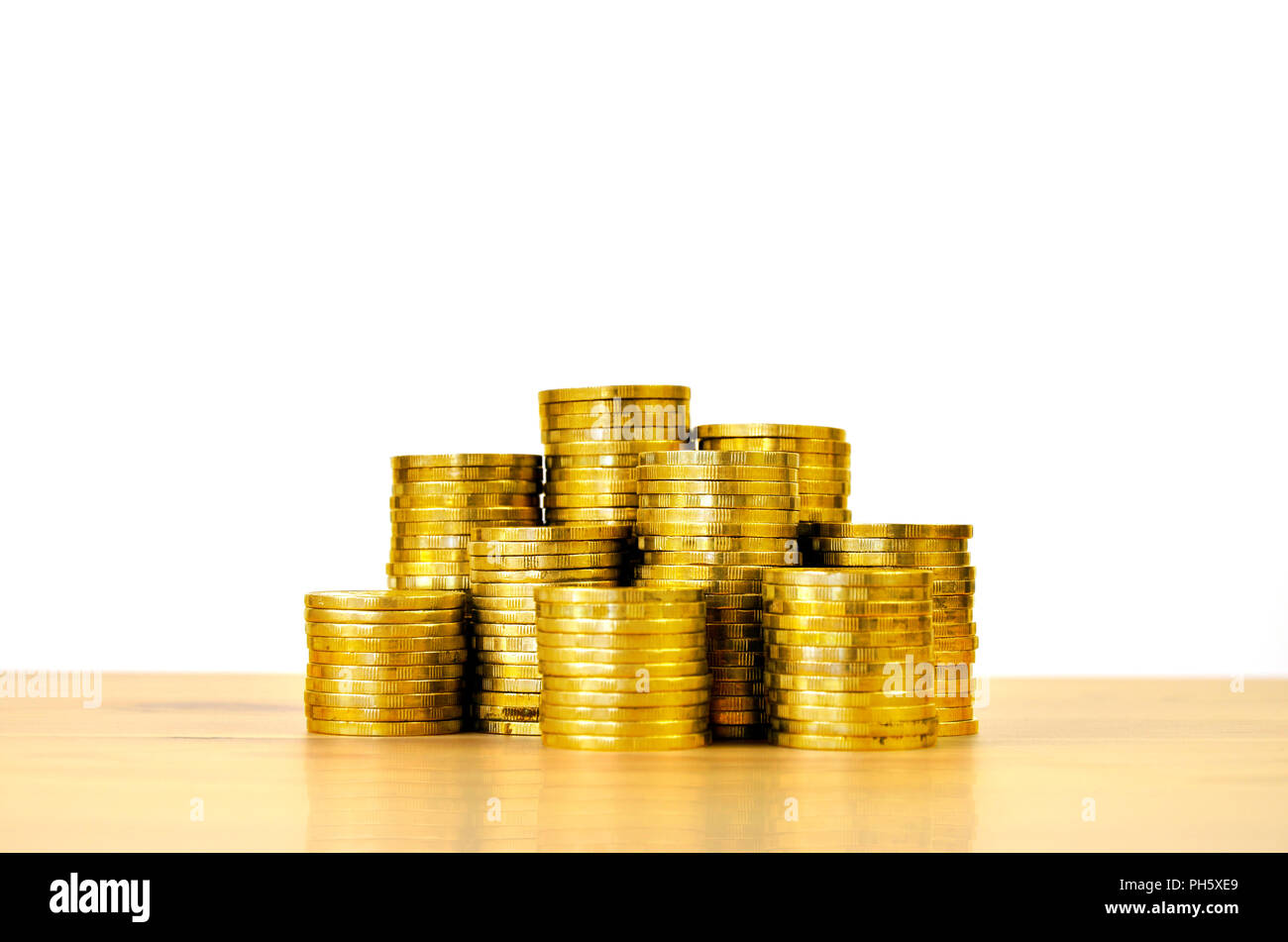 Plenty of gold coins on wood table isolated on white background with ...