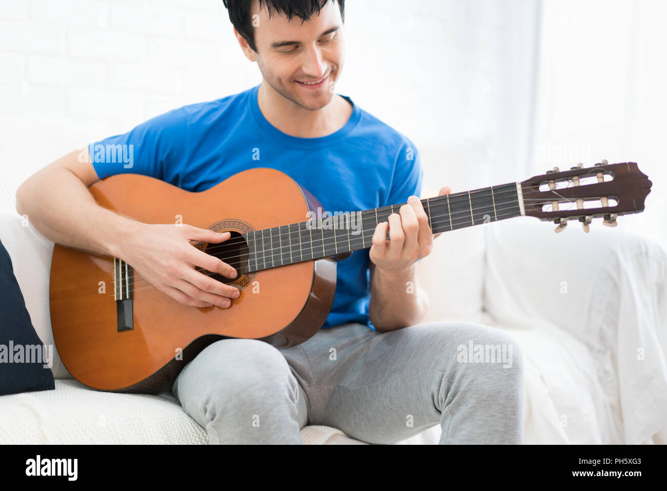 Asian young man hands playing acoustic guitar at home. Enjoy playing ...