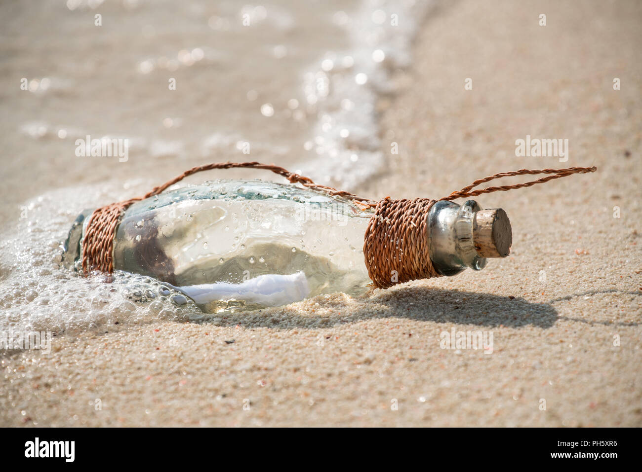 Letter message in a glass transparent bottle on the beach , concept for ...