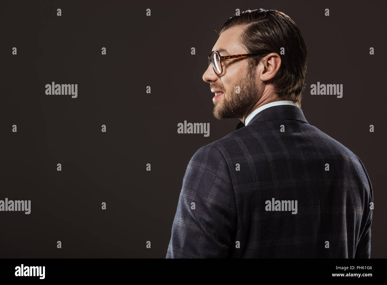 back view of handsome smiling man in eyeglasses looking away isolated ...
