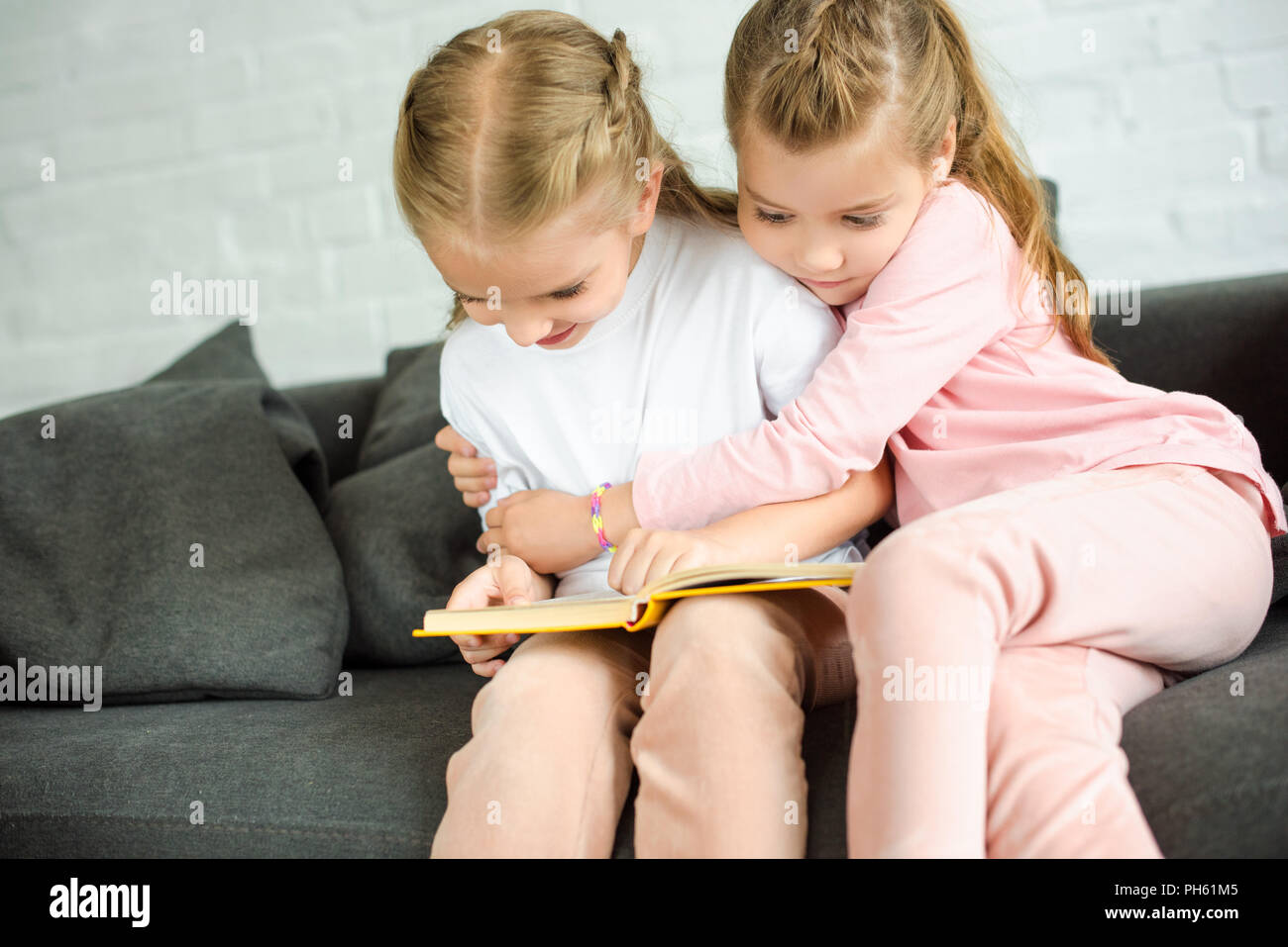 Sisters reading book hi-res stock photography and images - Alamy