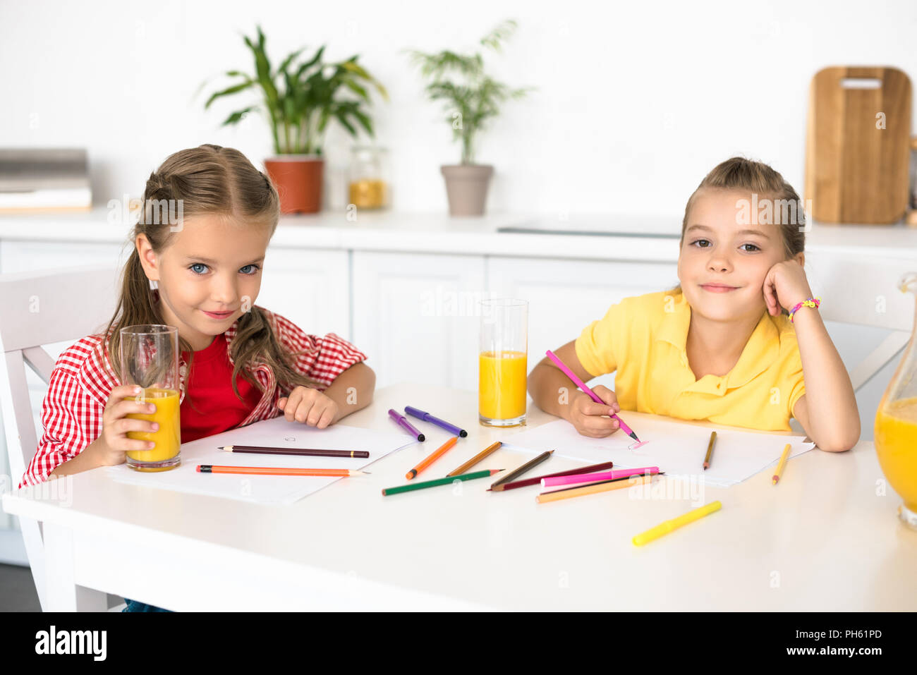 portrait of cute smiling little kids looking at camera while drawing ...