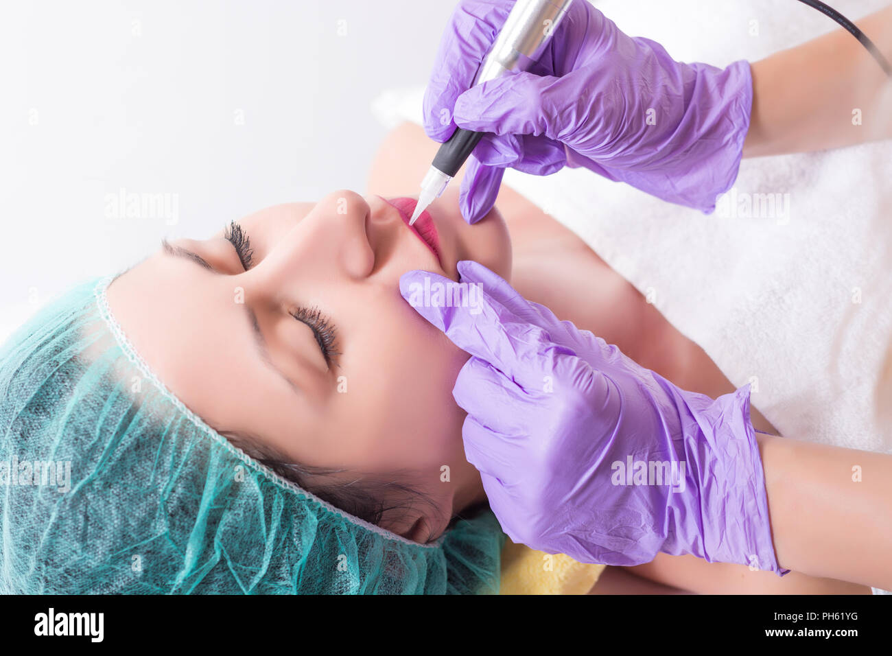 Professional permanent makeup applying on woman lips in beauty studio ...