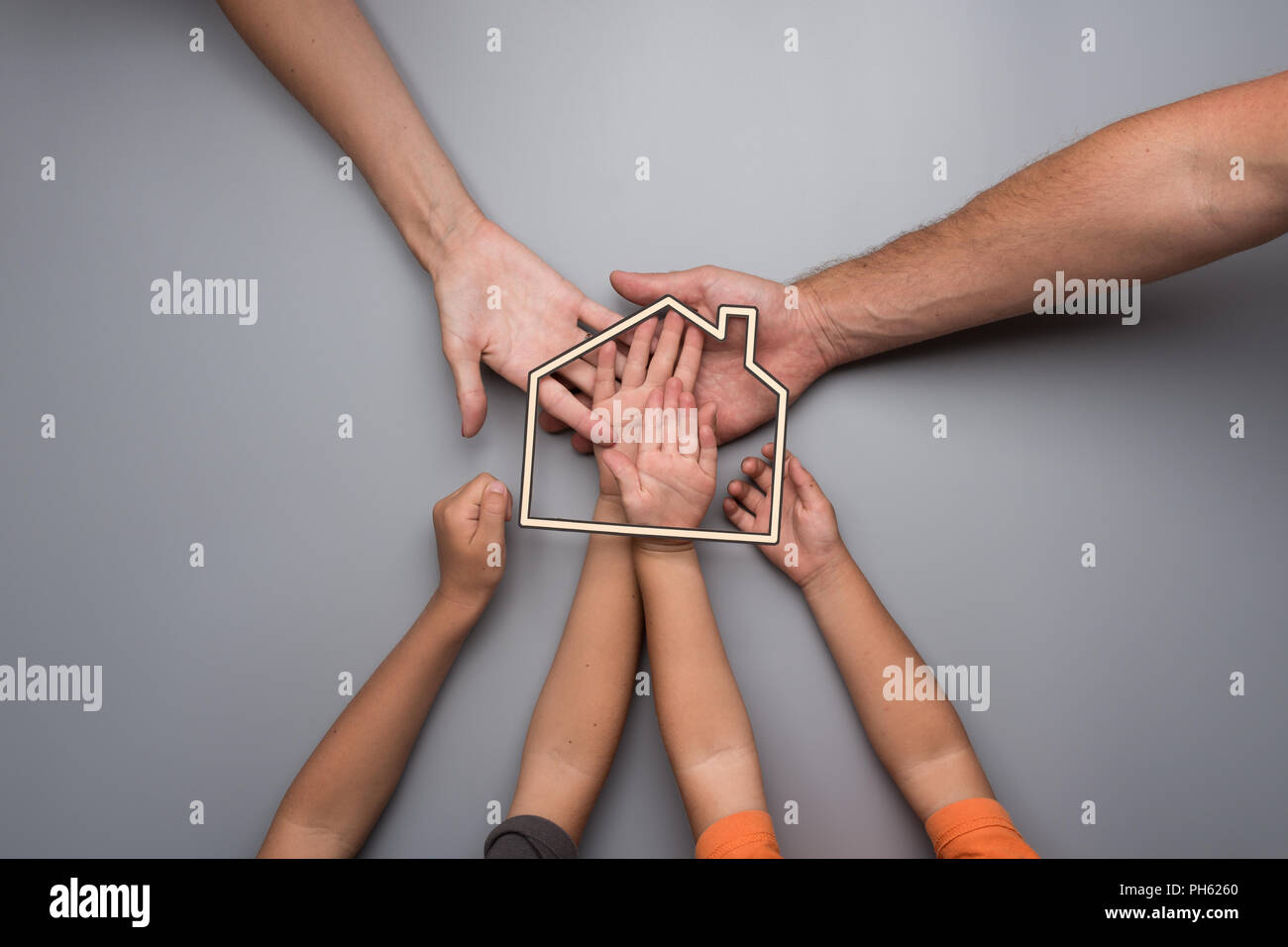 Top view of parents and children holding the shape of a residential ...
