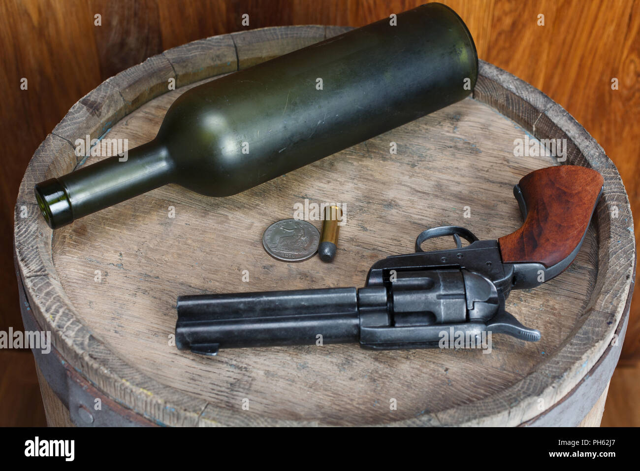 Old western revolver with cartridges and silver dollar on wooden barrel ...
