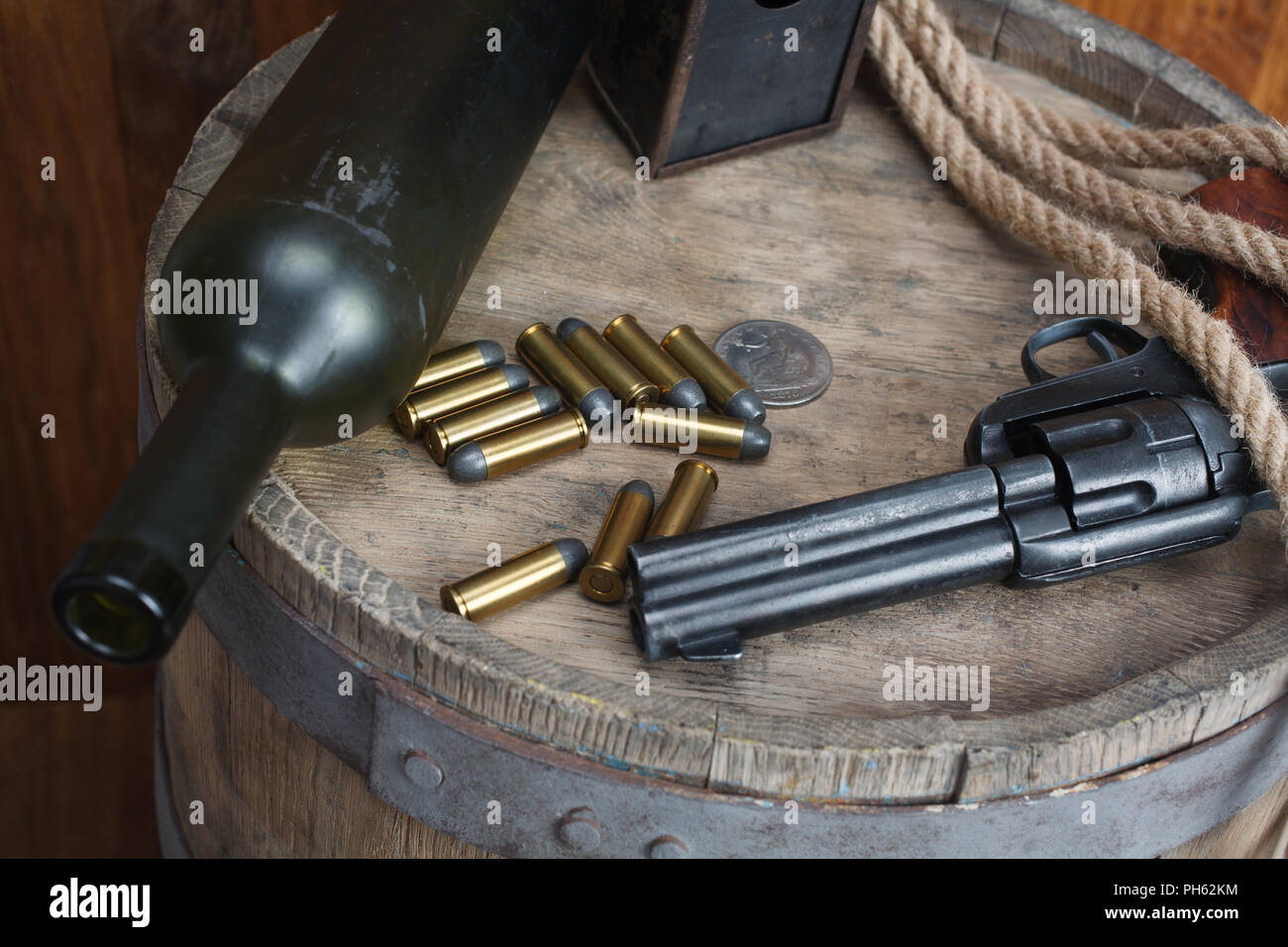 Old western revolver with cartridges and silver dollar on wooden barrel ...