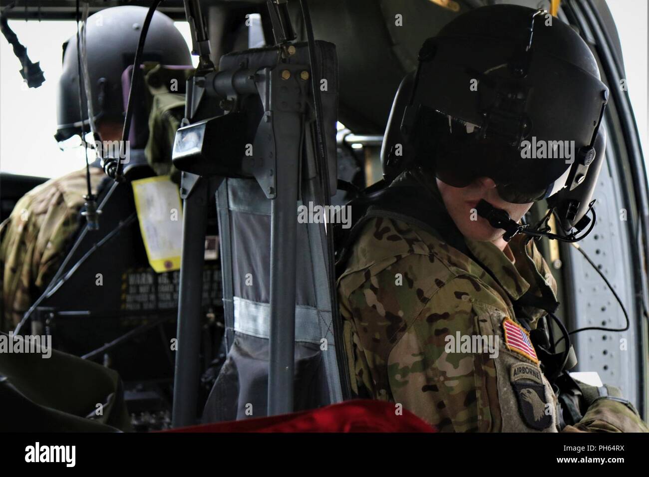 A Texas National Guard helicopter crew member peers out the window ...