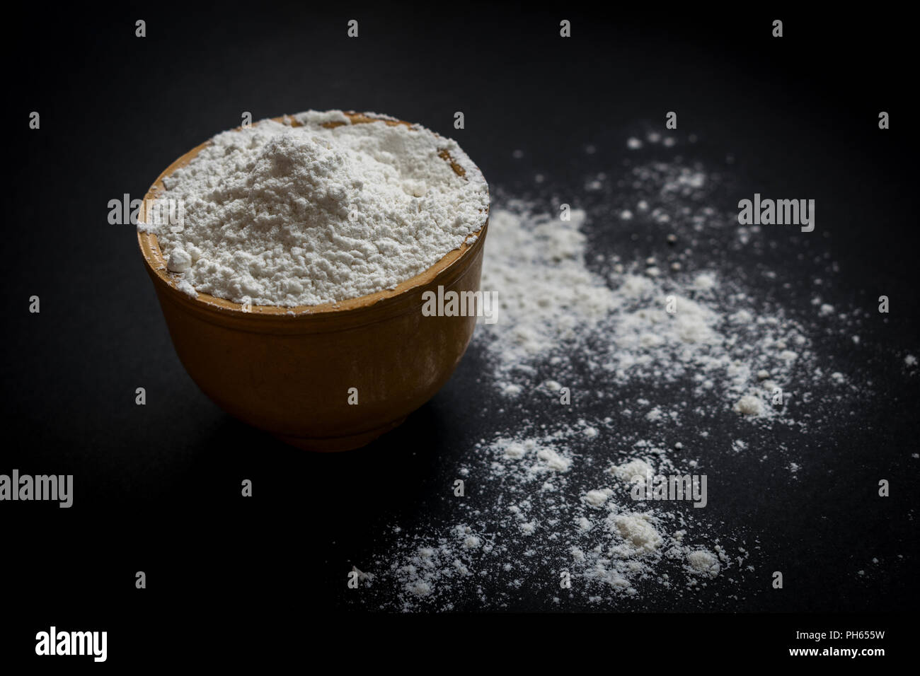 flour in a bowl on a black table stained with more flour Stock Photo ...