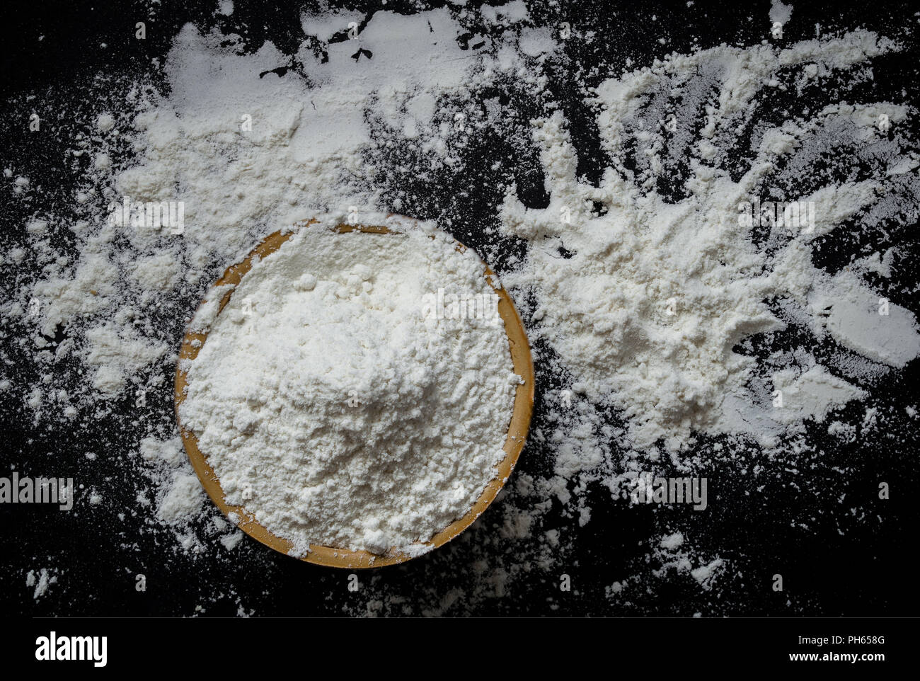 flour in a bowl on a black table stained with more flour Stock Photo ...