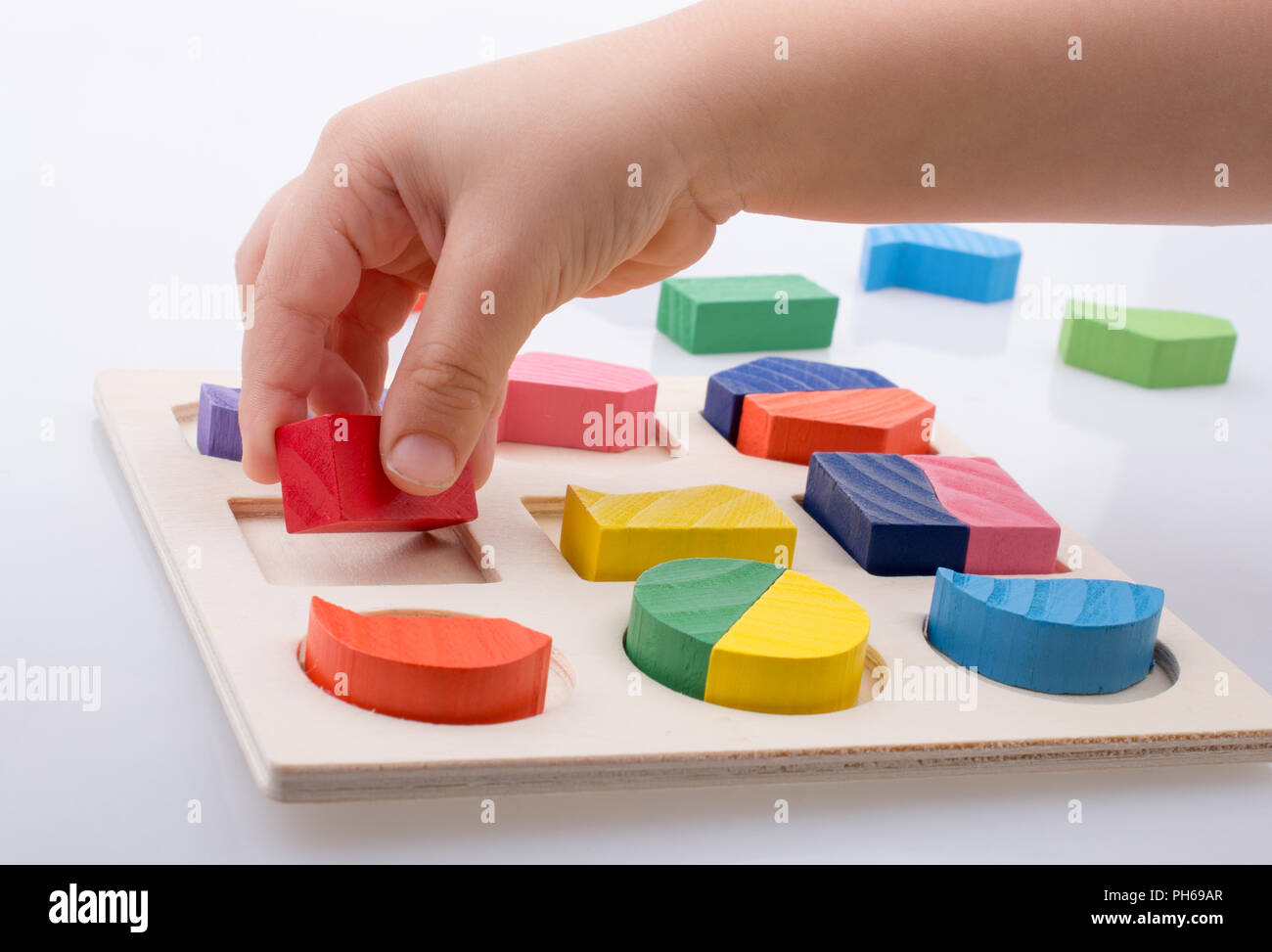 Colorful wooden pieces of a logic puzzle in hand Stock Photo - Alamy