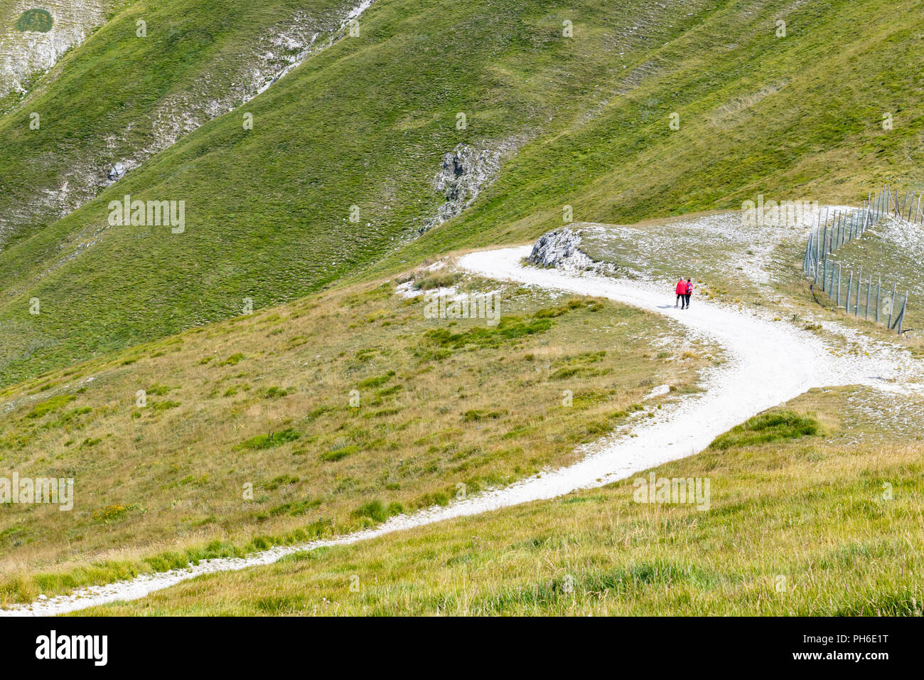 Human couple on mountain path long shot trekking walking summertime ...