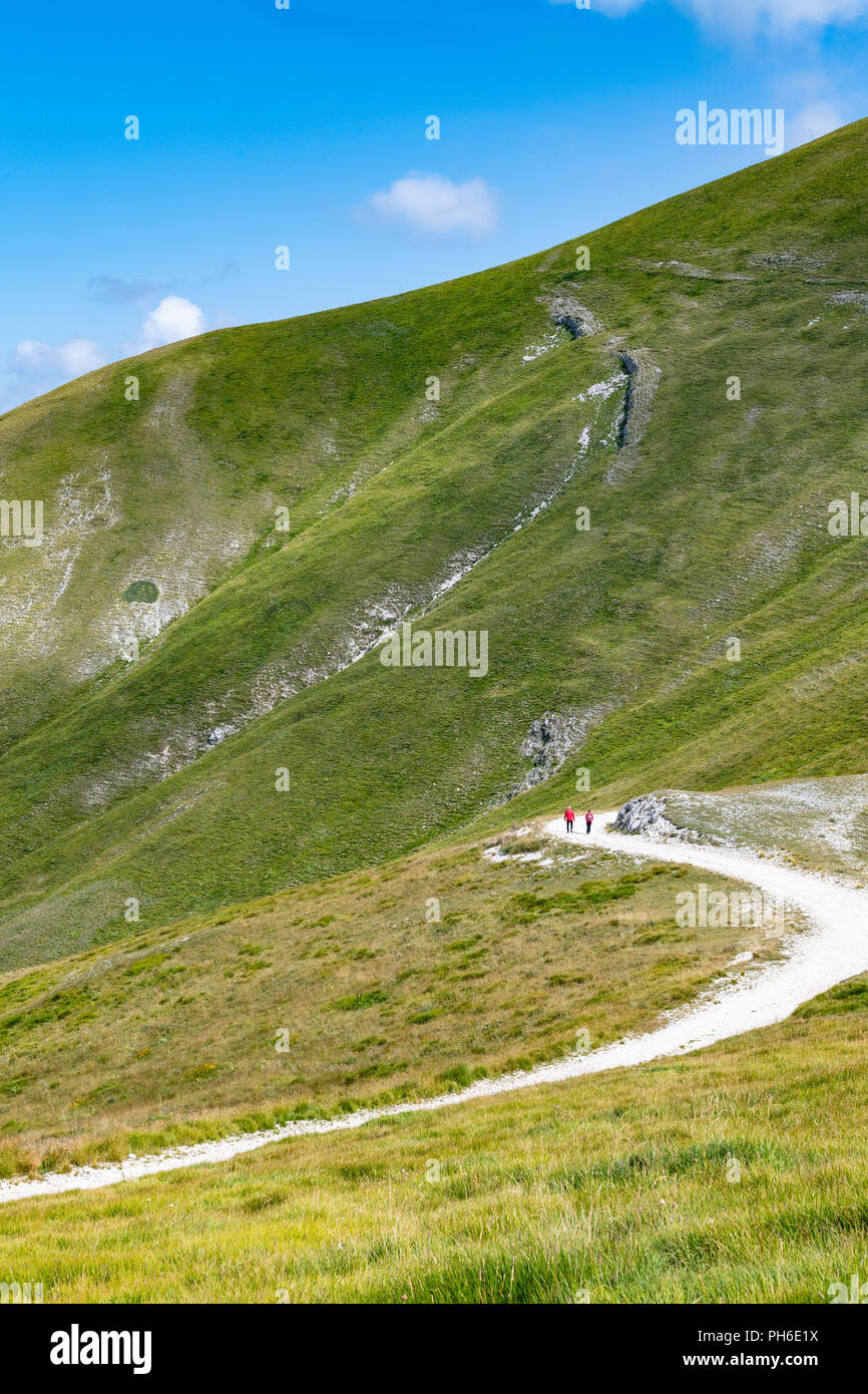Human couple on mountain path long shot trekking walking summertime ...