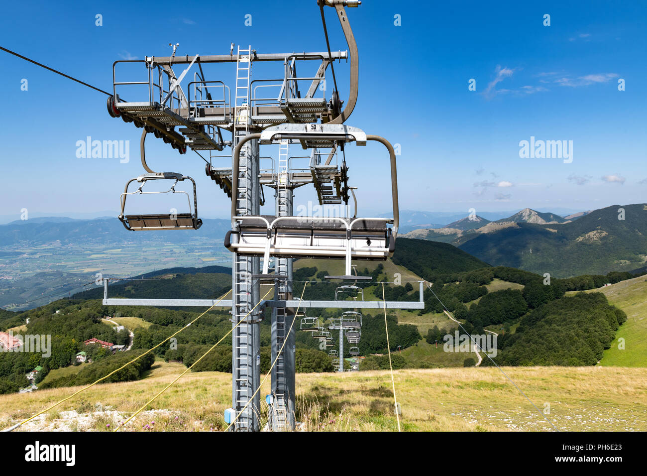 Ski lift infrastructure in summertime on mountain top, landscape green ...