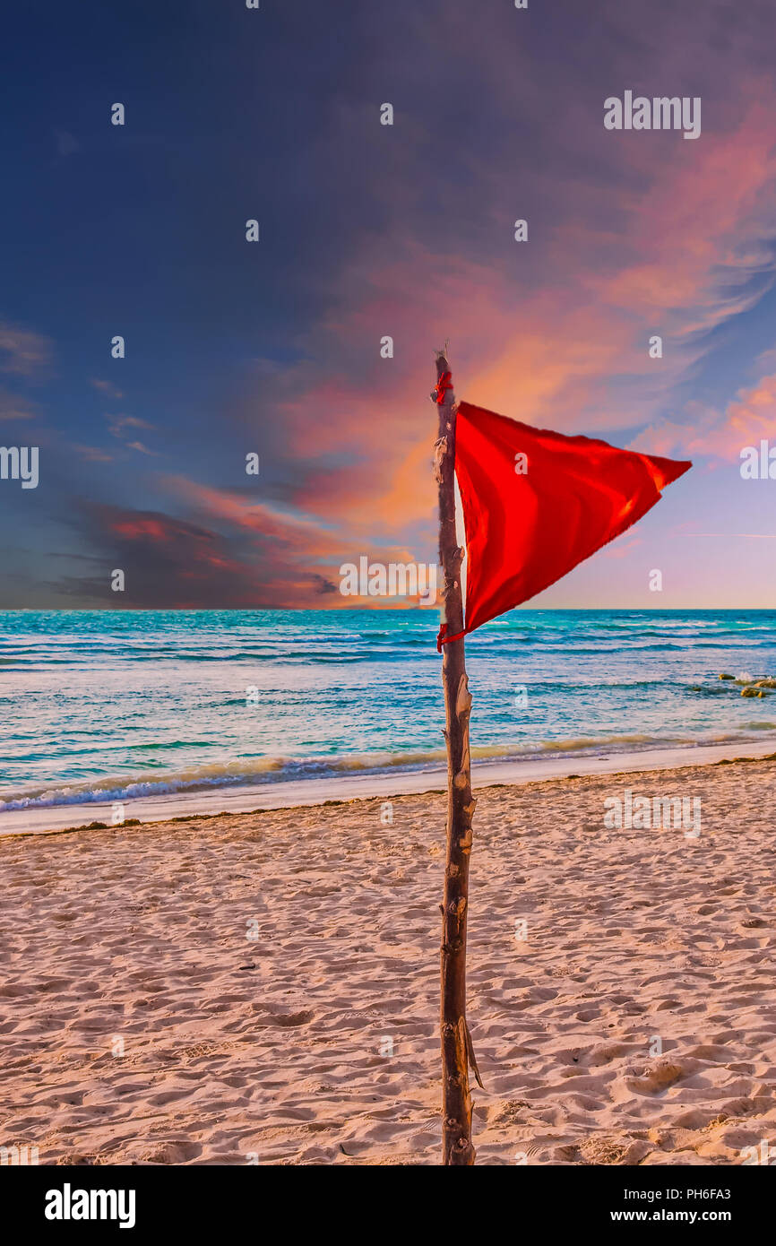 A red warning flag blowin in the wind on a beach Stock Photo - Alamy