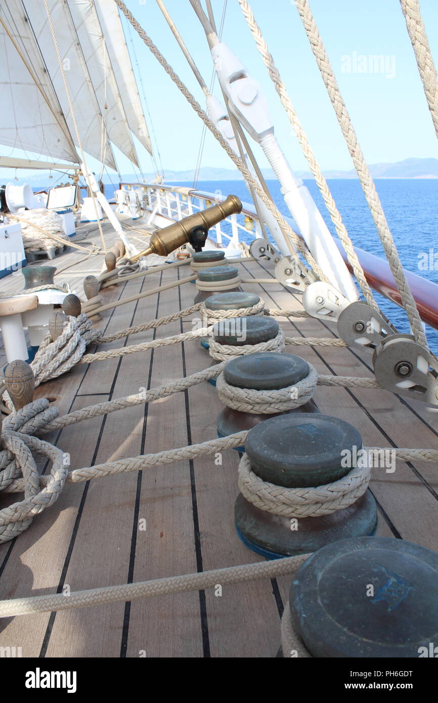 Main deck of a clipper ship showing a brass cannon with rope holders ...