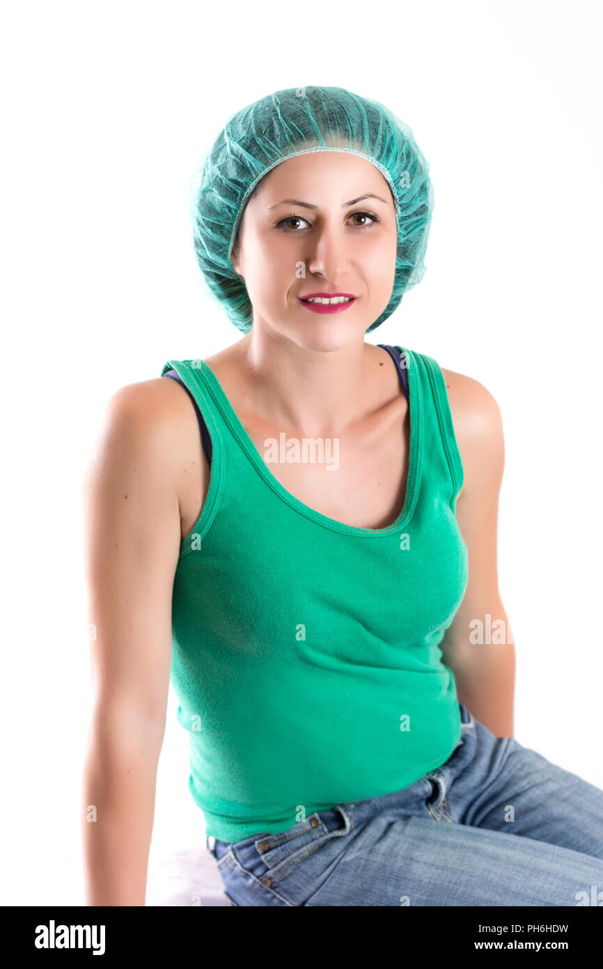 Happy female patient wearing green surgical protection cap sitting on ...